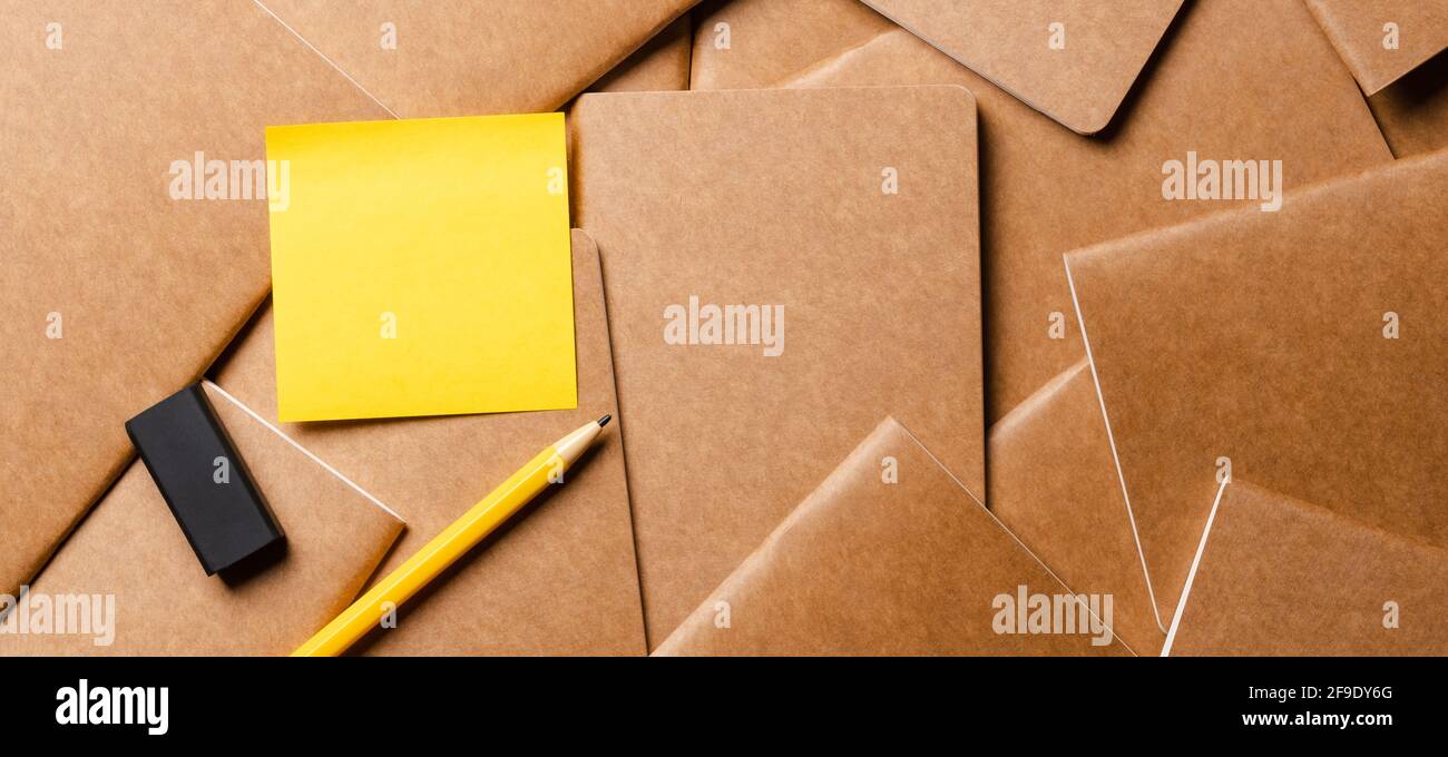 yellow sticky note on kraft brown notebook on table background ...