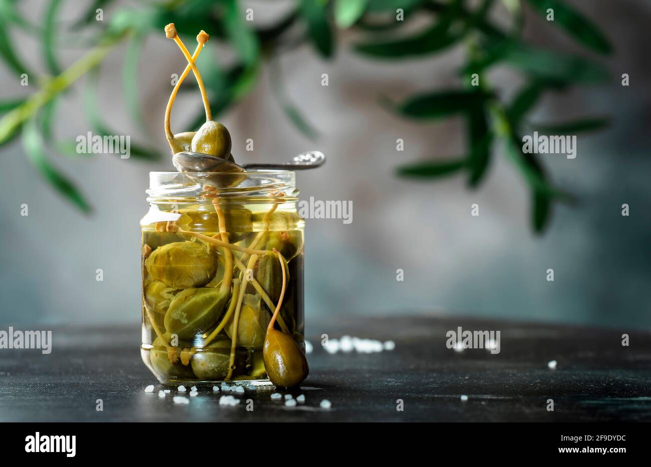 Capers. Marinated or pickled canned capers fruit close up in glass jar ...