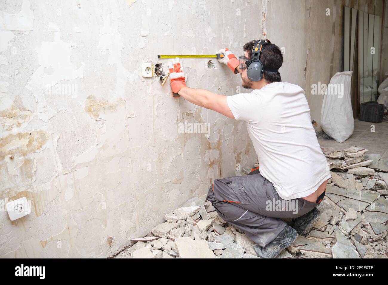Builder man using a measuring tape at the construction site ...