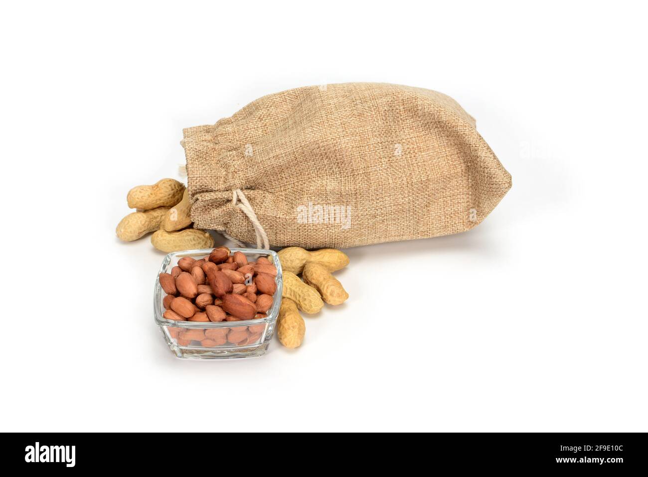 Peanuts. Jute burlap sack full of peanuts and glass bowl with peeled ...
