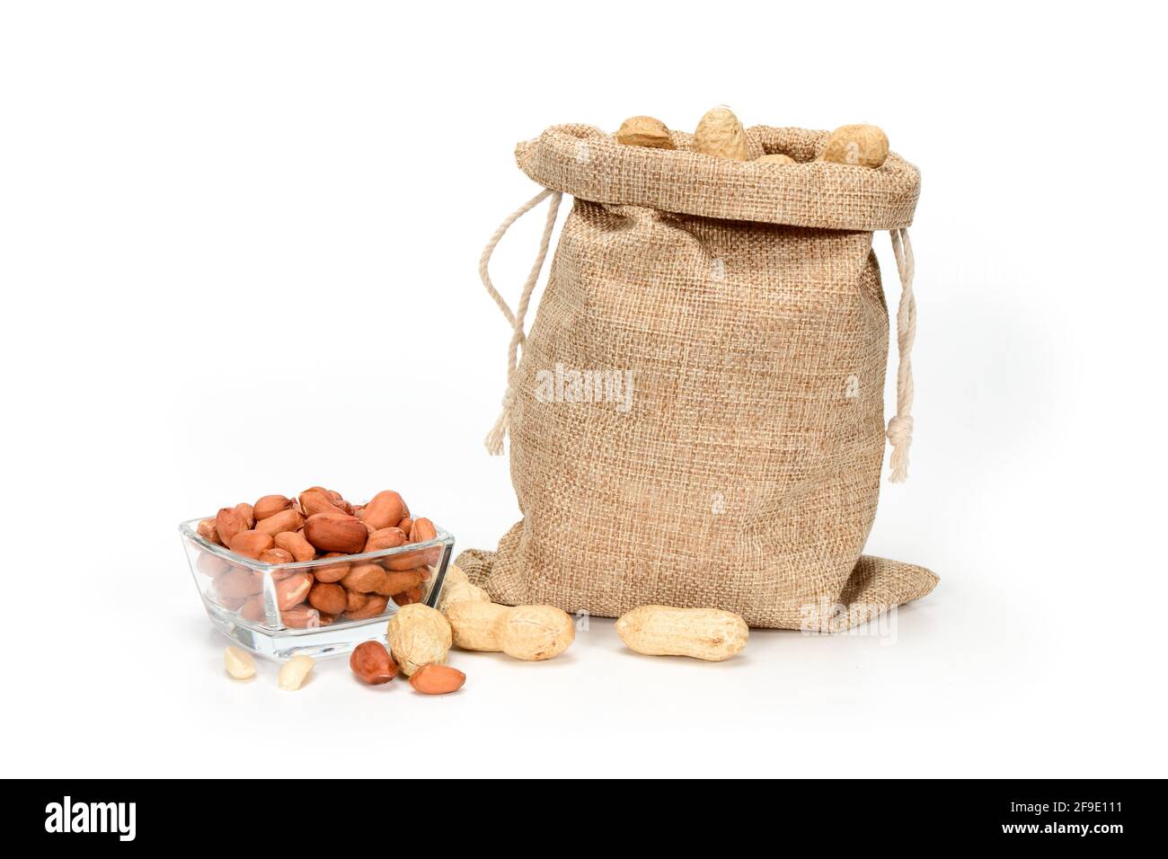 Peanuts. Jute burlap sack full of peanuts and glass bowl with some ...
