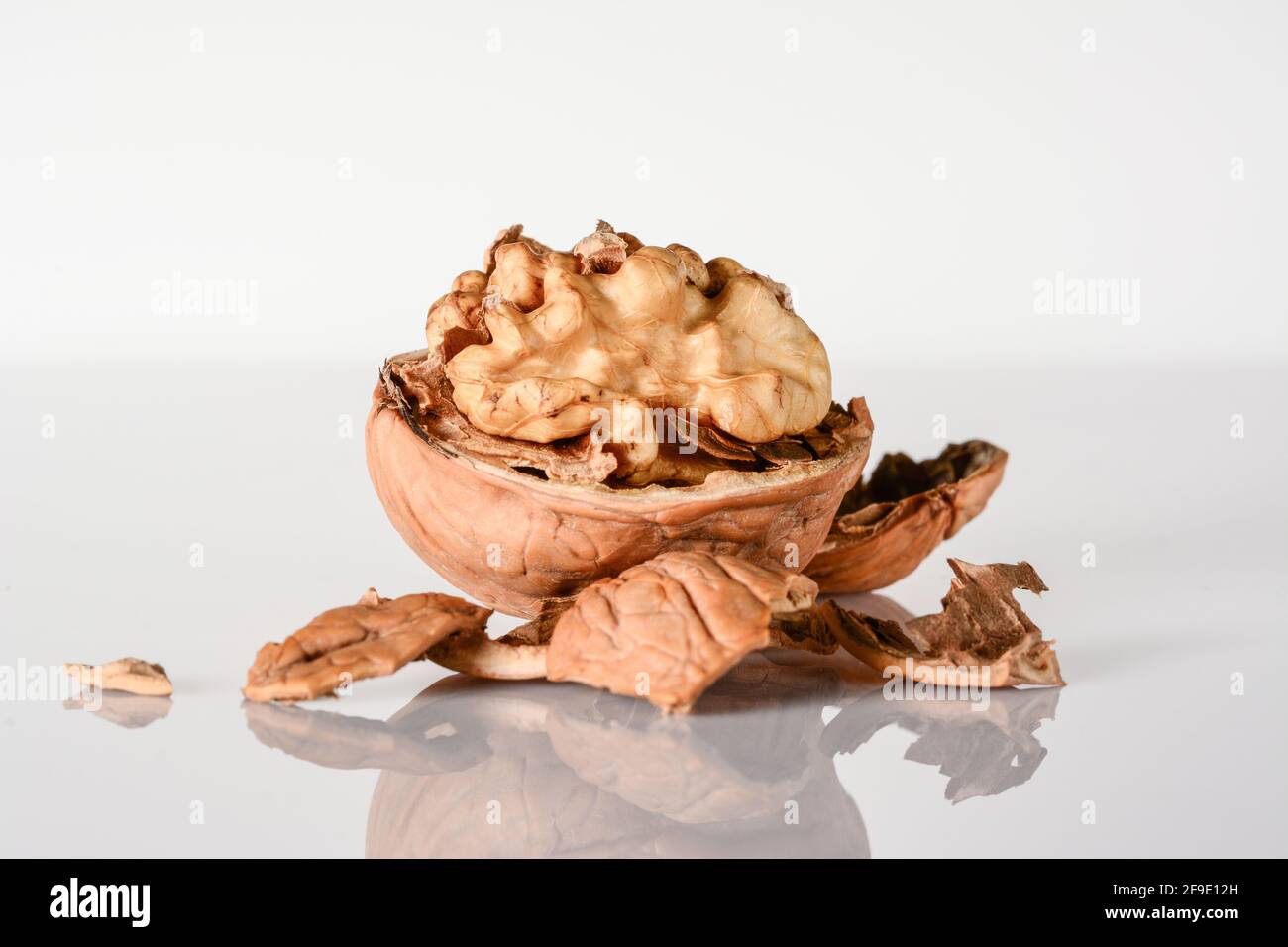 Broken walnut with reflection on a glass desk,, close-up macro Stock ...