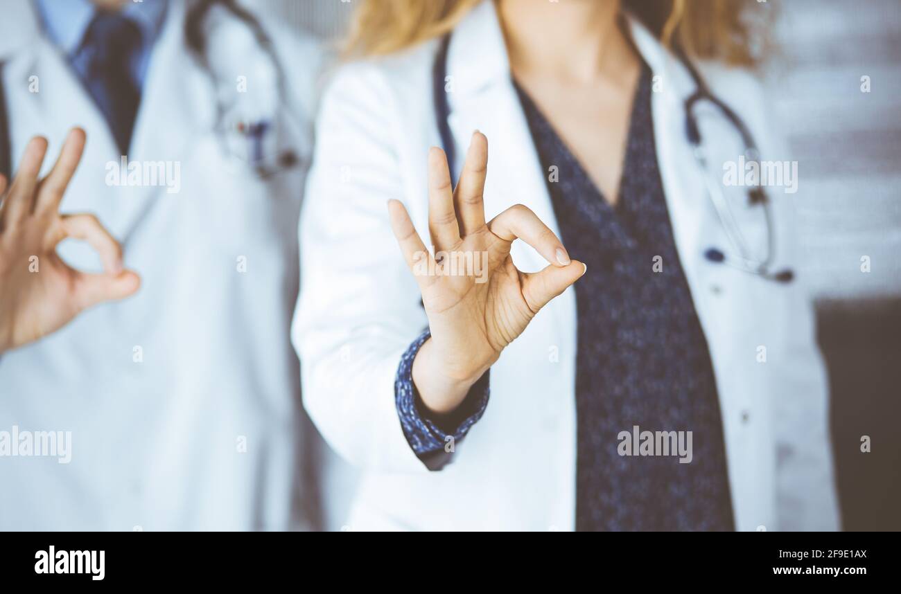 Two doctors standing with Ok sign in hospital office. Medical help ...