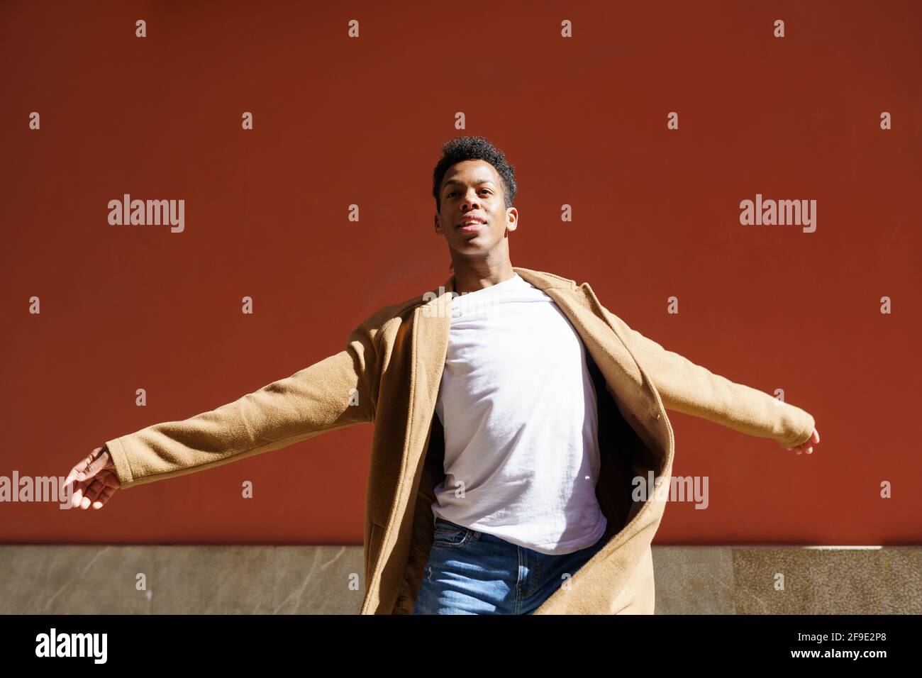Young Cuban man dancing on red urban wall Stock Photo - Alamy