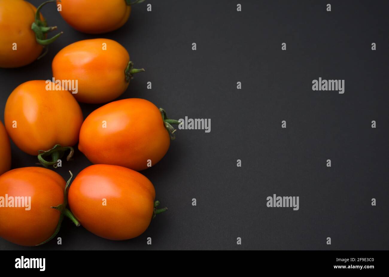 Tomatoes flat lay on black background. Tilted top view shot, horizontal ...