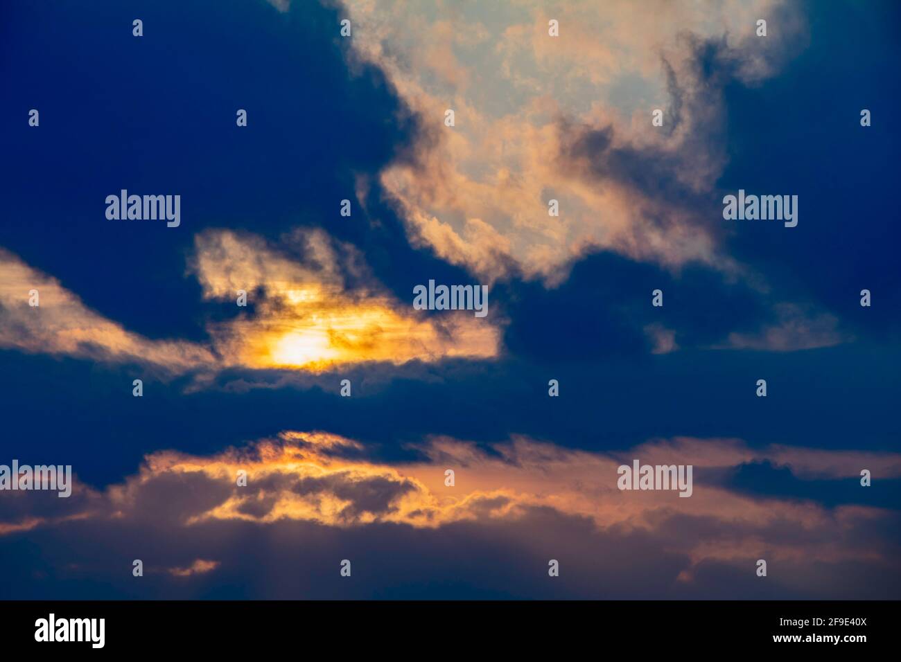 The setting sun lighting up the underside of the cloud cover with a ...