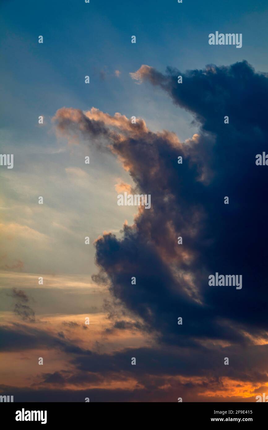 The setting sun lighting up the underside of the cloud cover with a ...