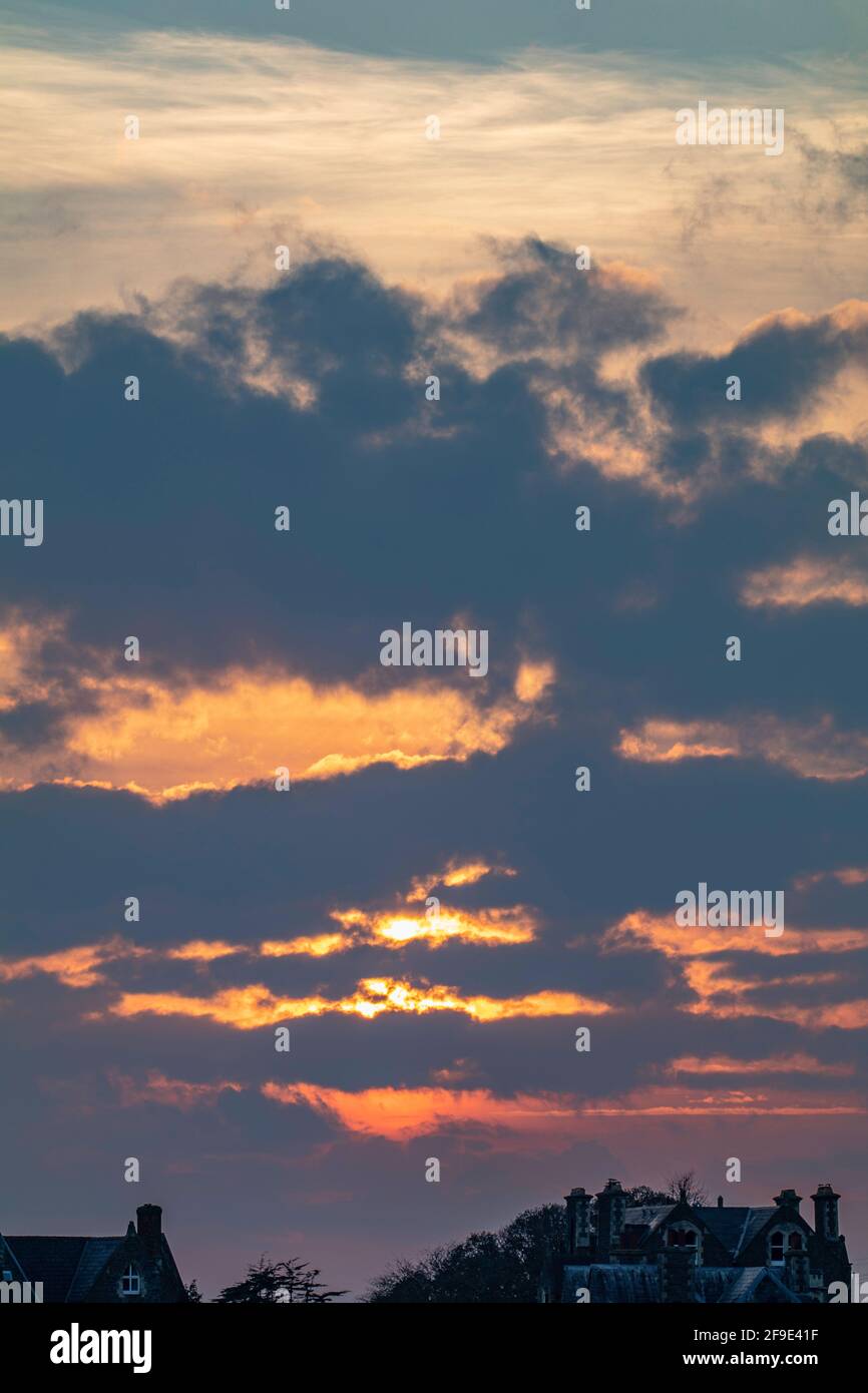 The setting sun lighting up the underside of the cloud cover with a ...