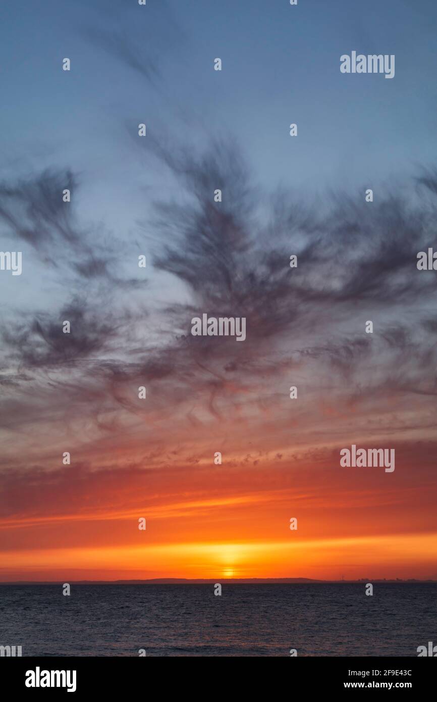 The setting sun lighting up the uderside of the cloud cover with a ...