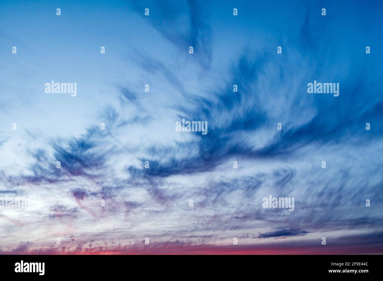 The setting sun lighting up the uderside of the cloud cover with a ...