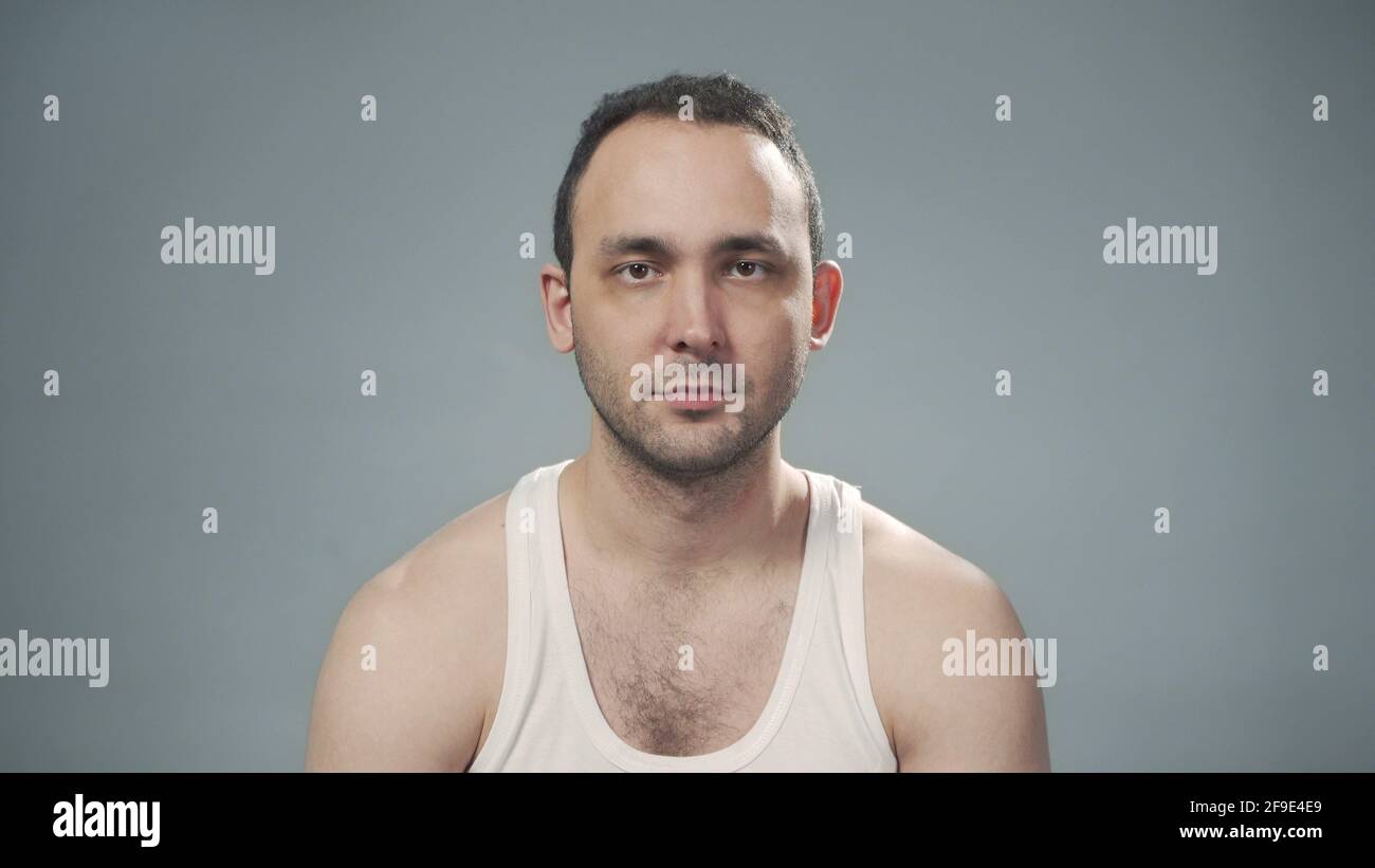 Photo of serious bristly man on gray background Stock Photo - Alamy