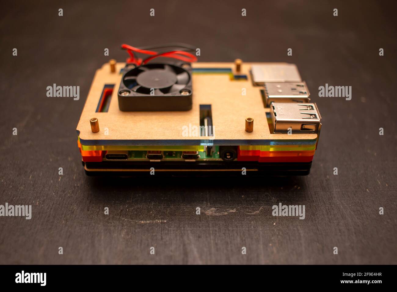 A single-board microboard computer in multi-colored case with a fan ...