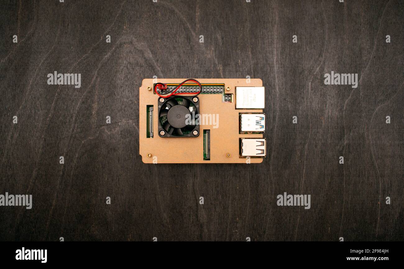 A single-board micro-computer in a case with a fan stands on a table ...