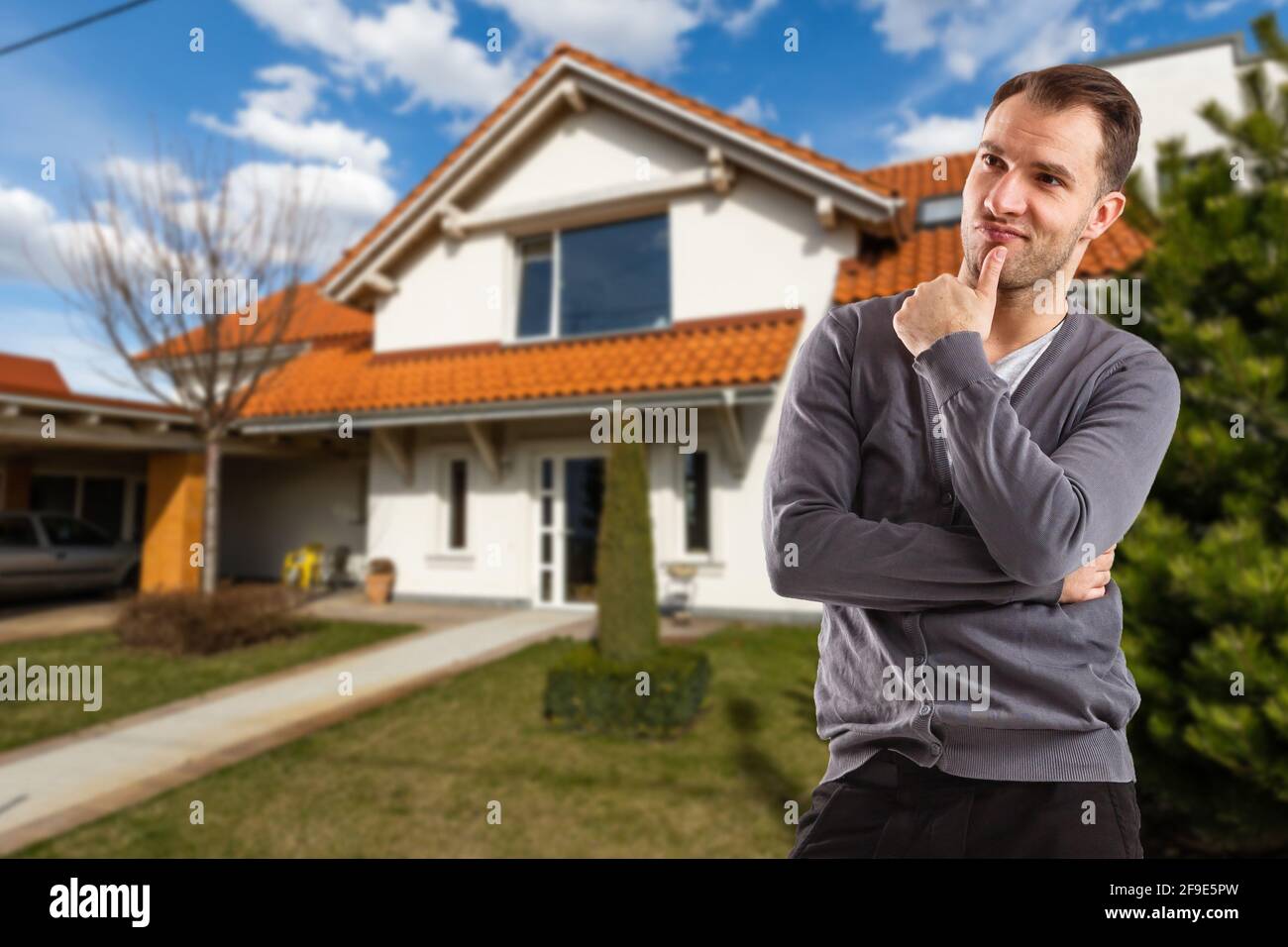 Cheerful man standing in front of new house Stock Photo - Alamy