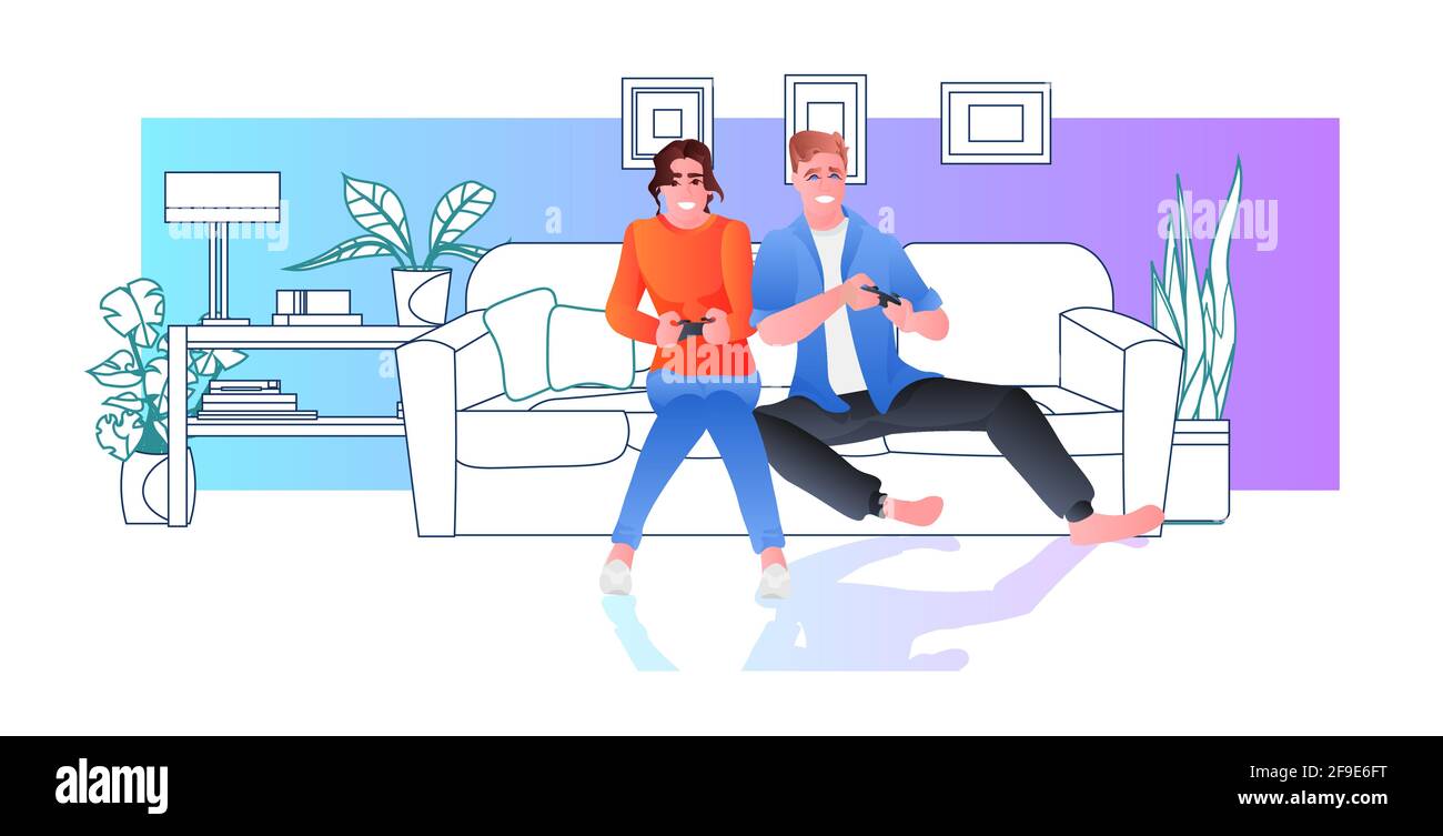 young couple using joysticks playing video games people spending time ...