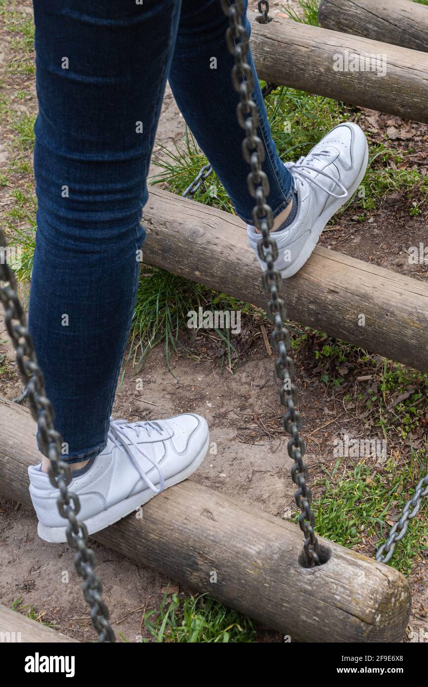 selective focus on the detail of legs crossing a bridge made of tree ...