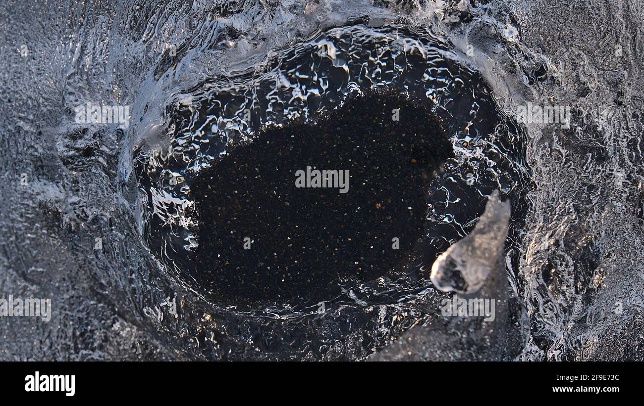 Close-up view of hole in small iceberg with shiny clear ice surface ...