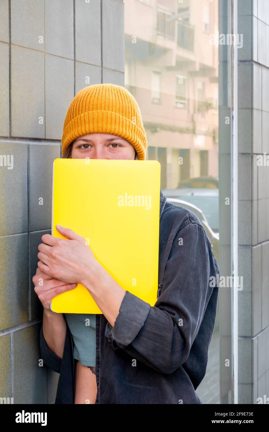 A shallow focus of a young Caucasian woman with a yellow beaning ...