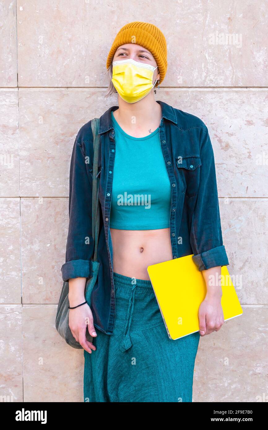 A vertical shot of a cool Spanish woman in face mask and bonnet with ...
