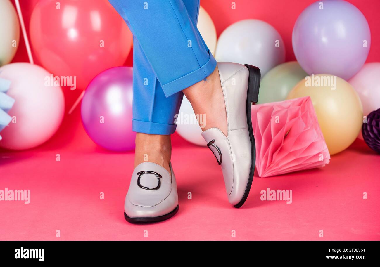 female feet in comfortable shoes loafers at colorful balloons, fashion ...