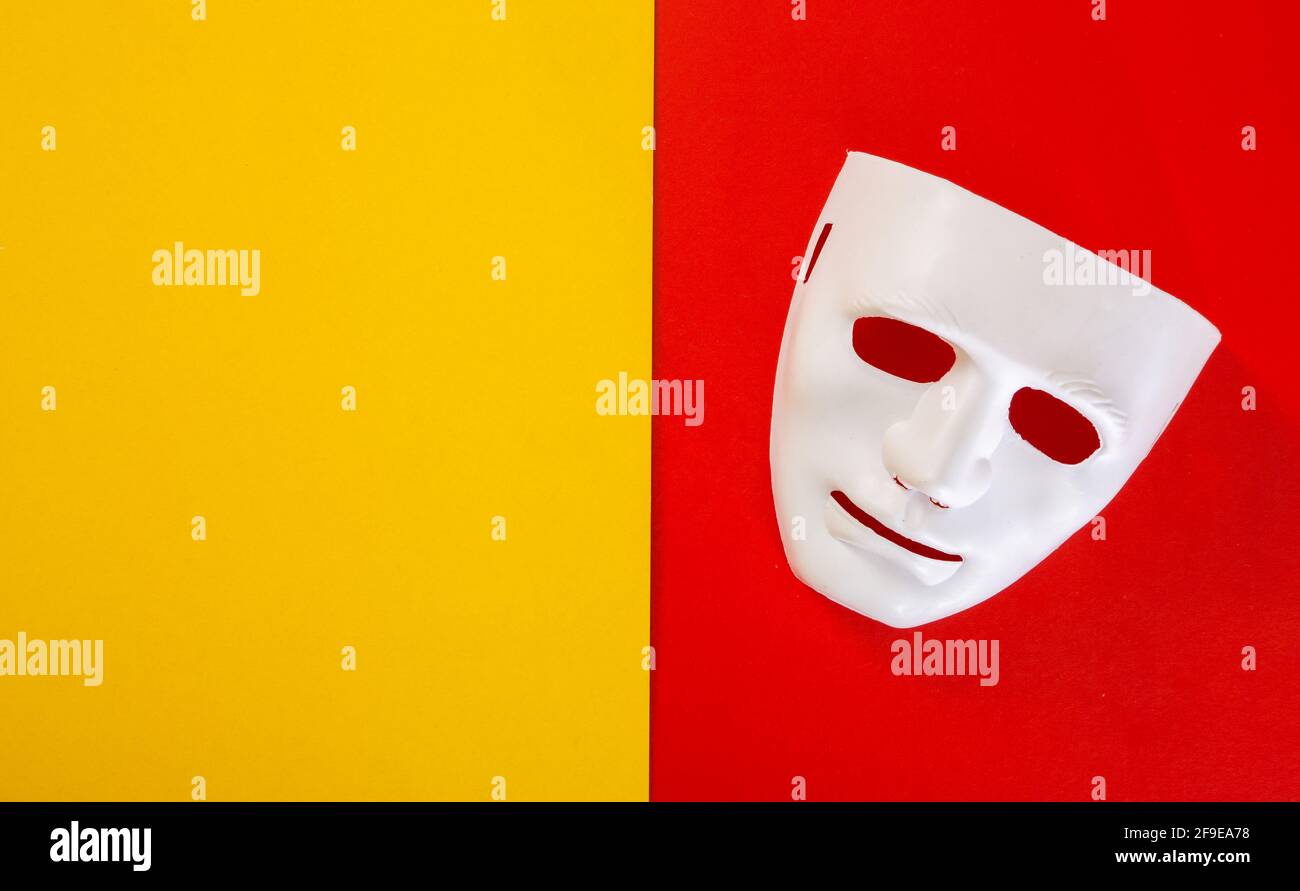 carnival white mask on red and yellow background Stock Photo - Alamy