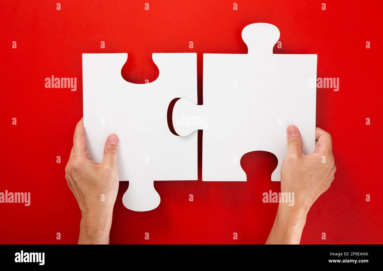 Concept of business,hand solving a puzzle piece on red background Stock ...