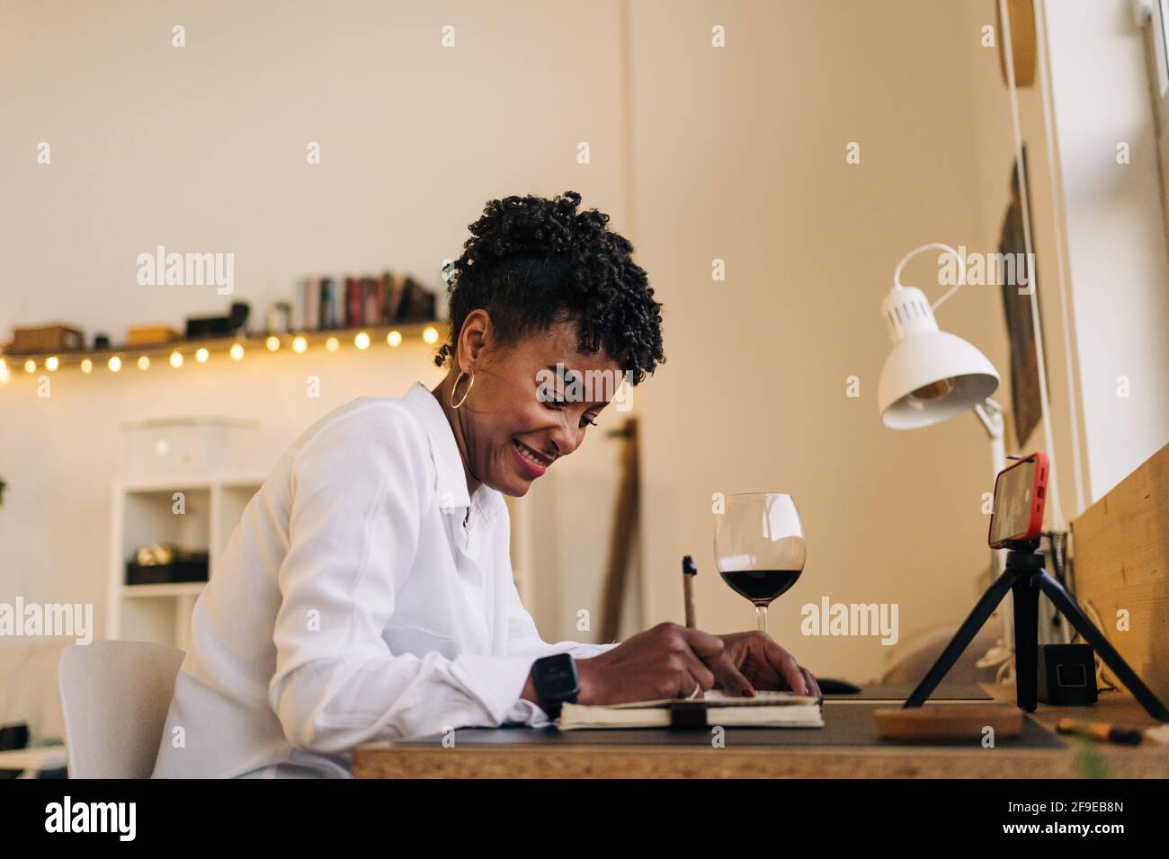Side view low angle of African American female writing in notebook ...