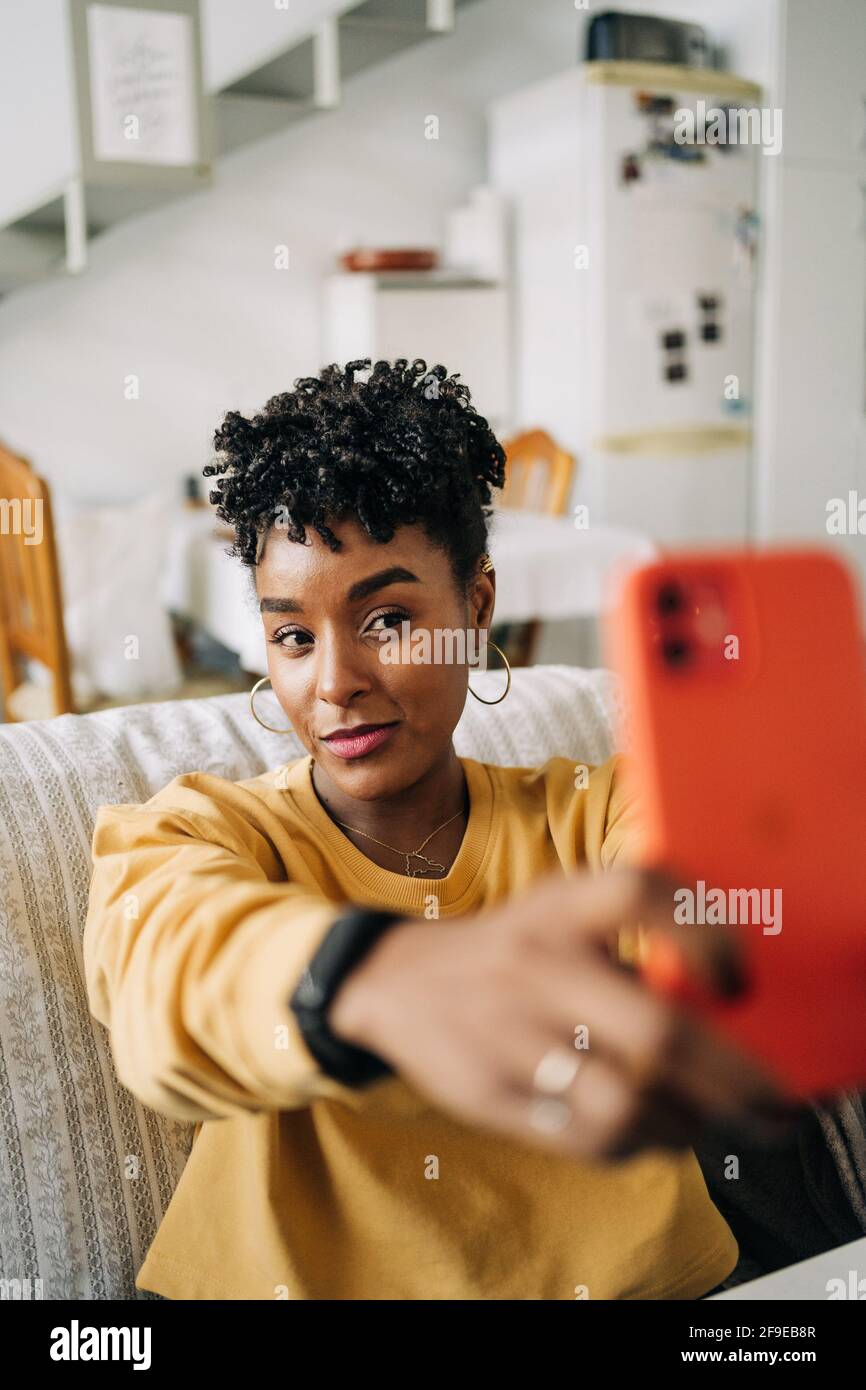 Charming African American female with curly hair taking self portrait ...