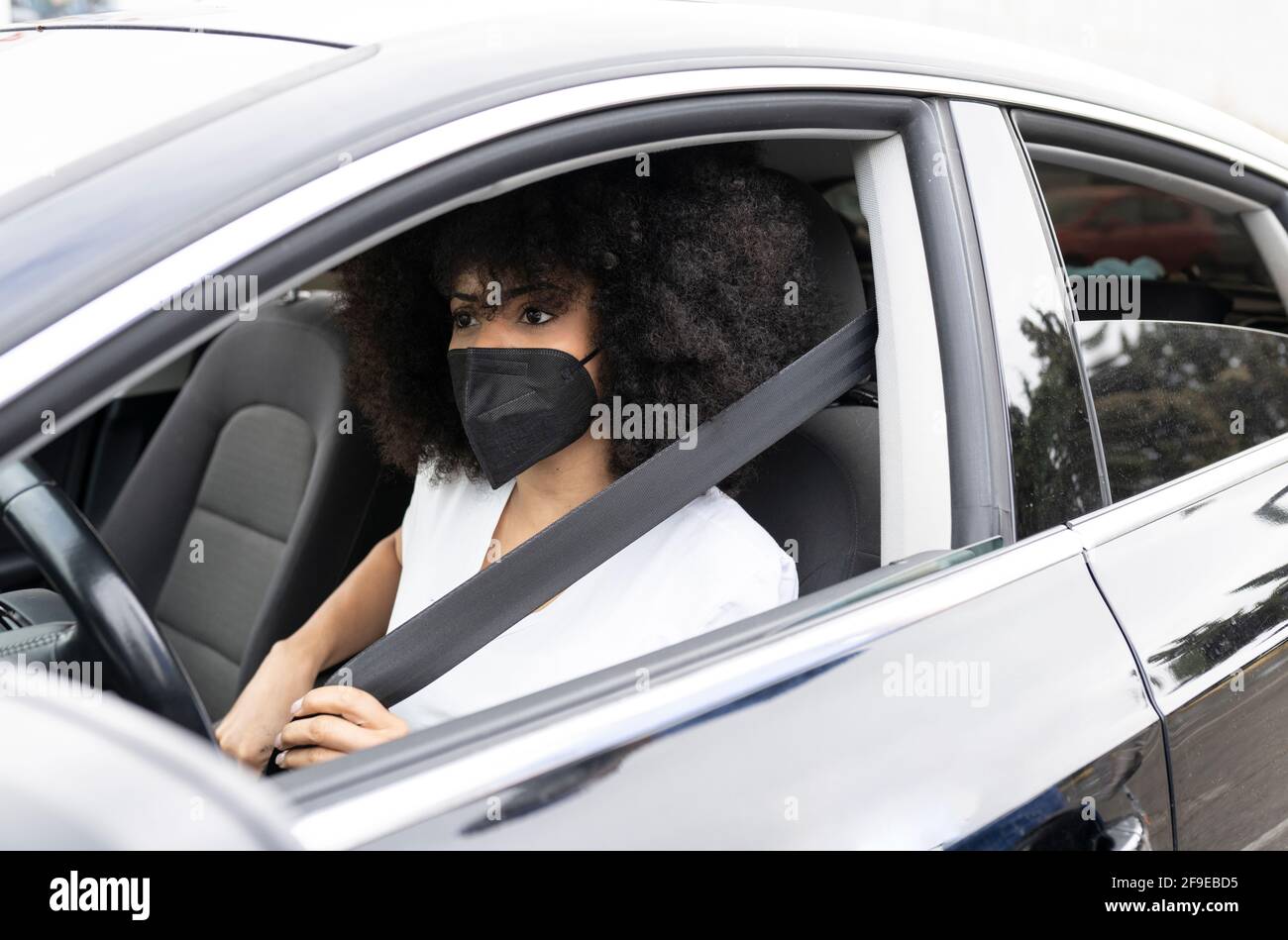 Side view of scared African American female patient with face mask ...