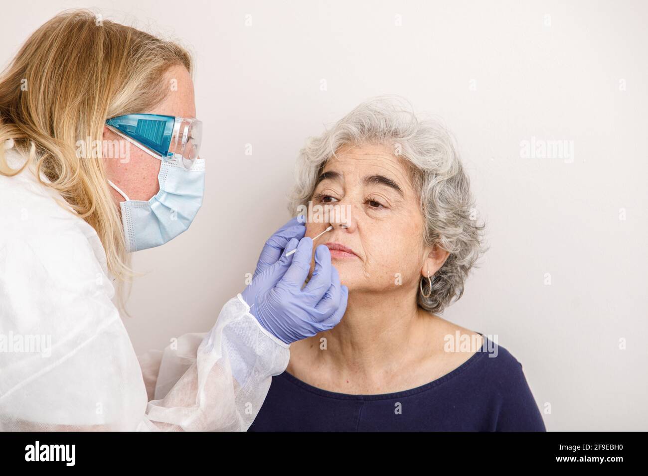 Woman performing a nasal PCR test on a patient Stock Photo - Alamy