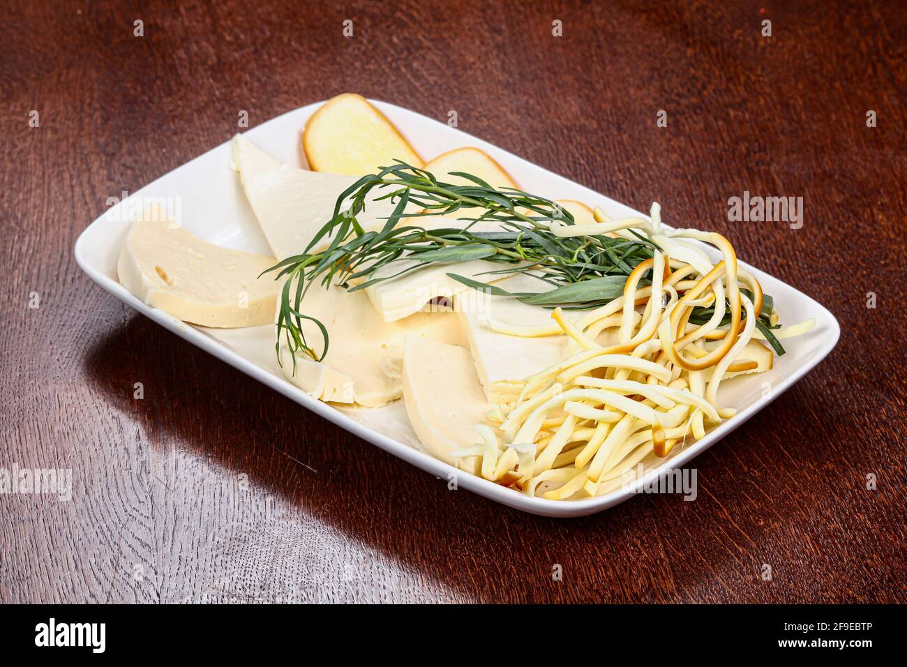 Caucasian tradition cheese plate served green herbs Stock Photo - Alamy