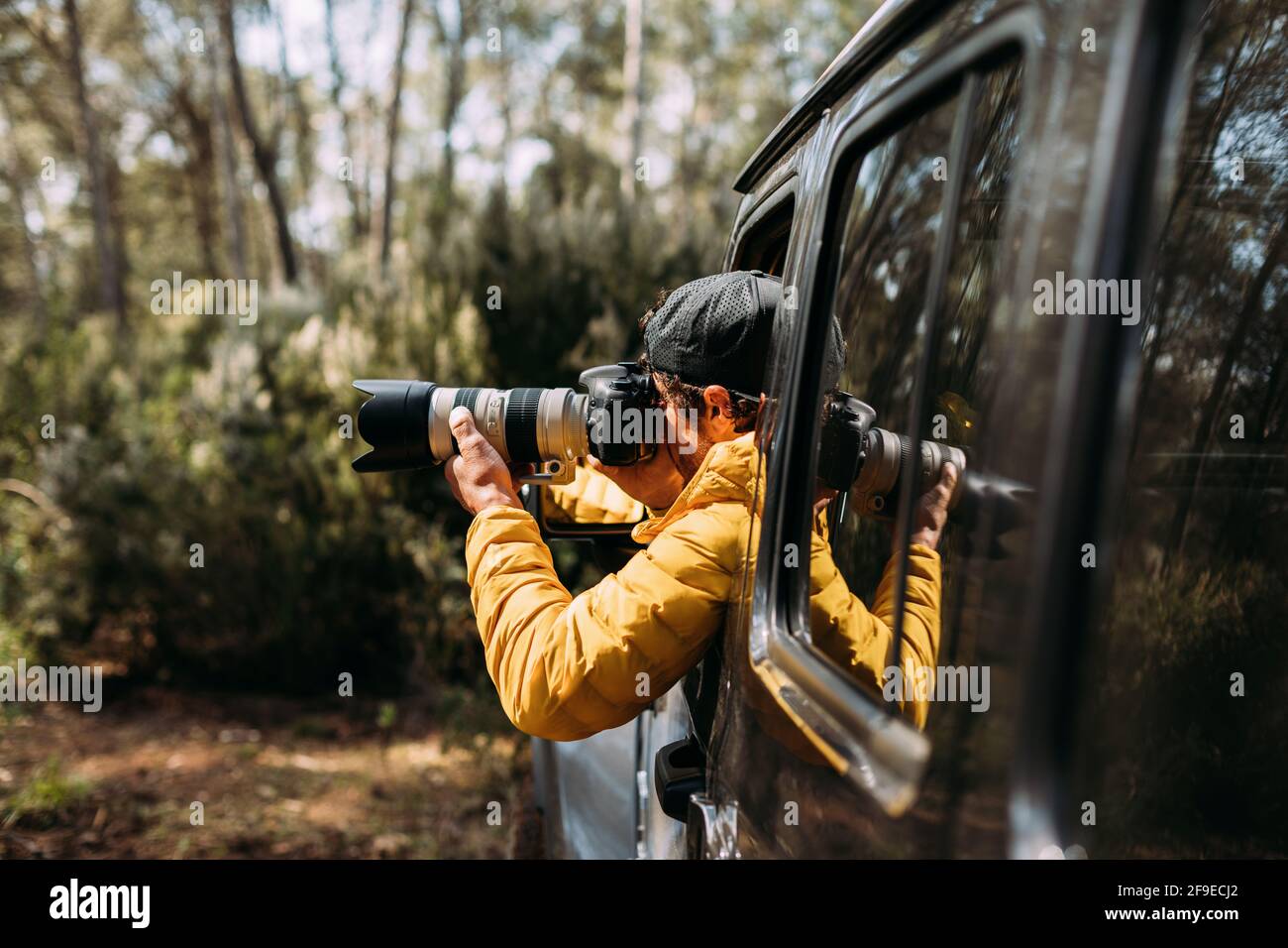 Side view of an adventurous photographer taking photos from inside his ...