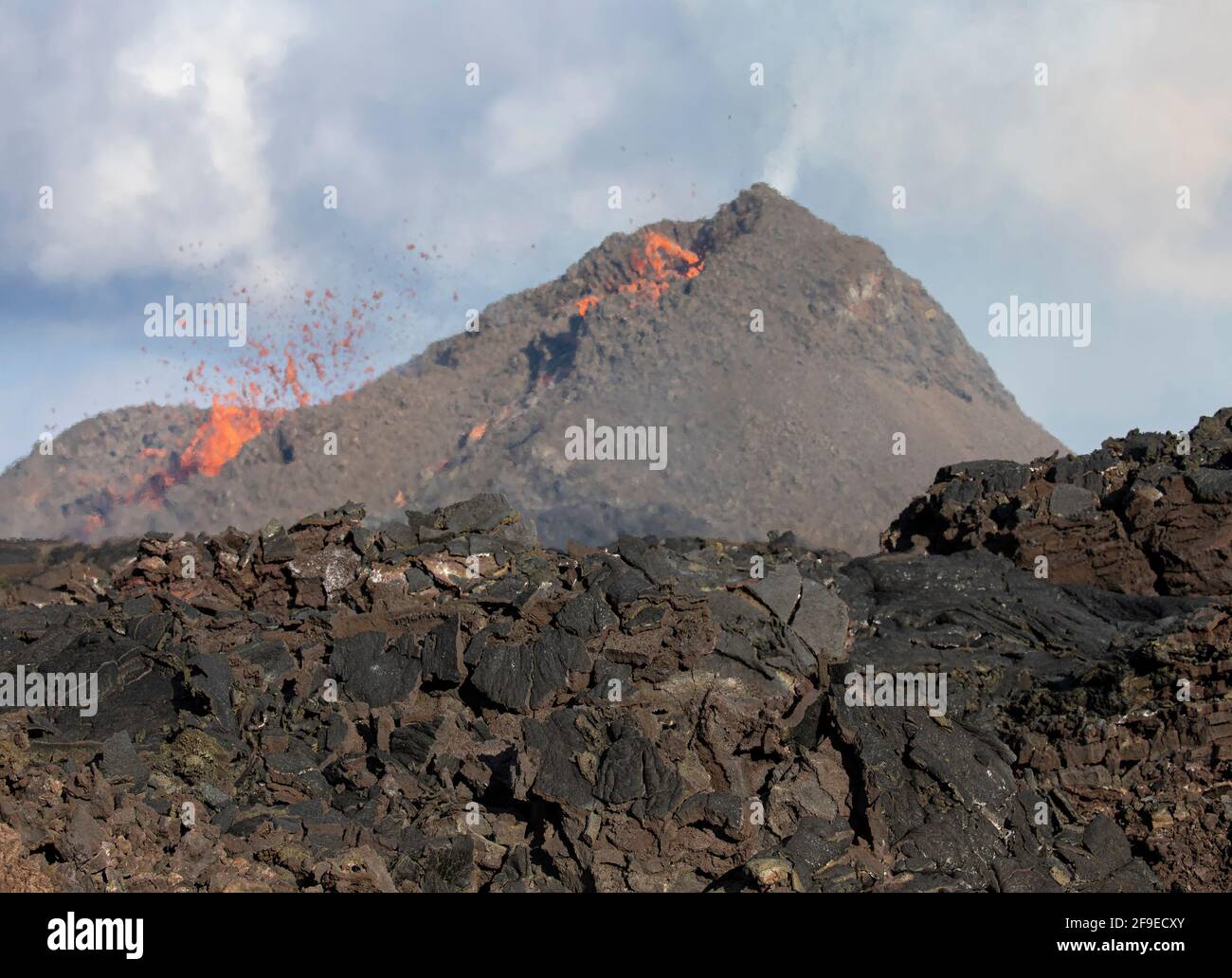 Side view of magma sparks out of the volcano hole and run like rivers ...