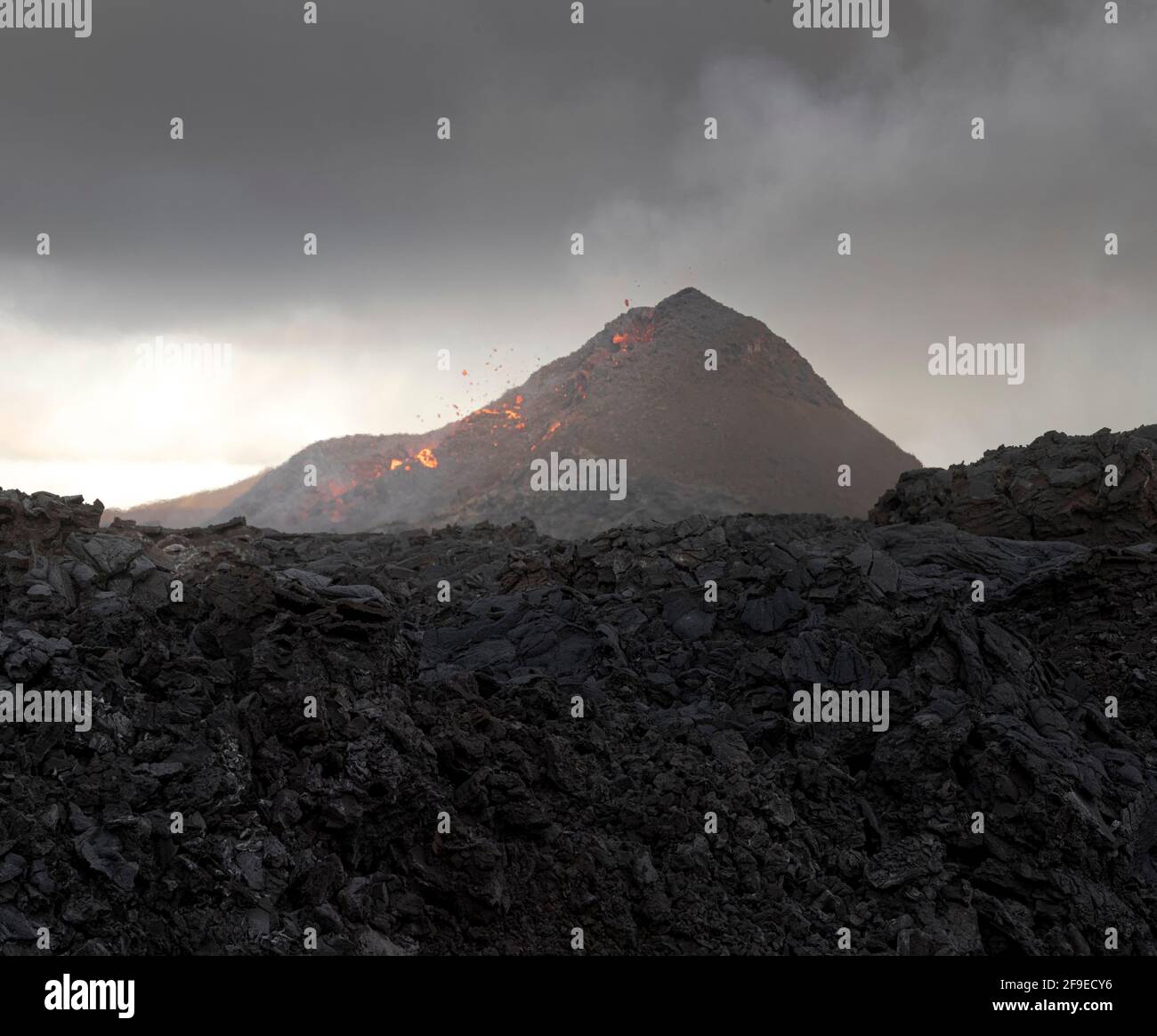 Side view of magma sparks out of the volcano hole and run like rivers ...