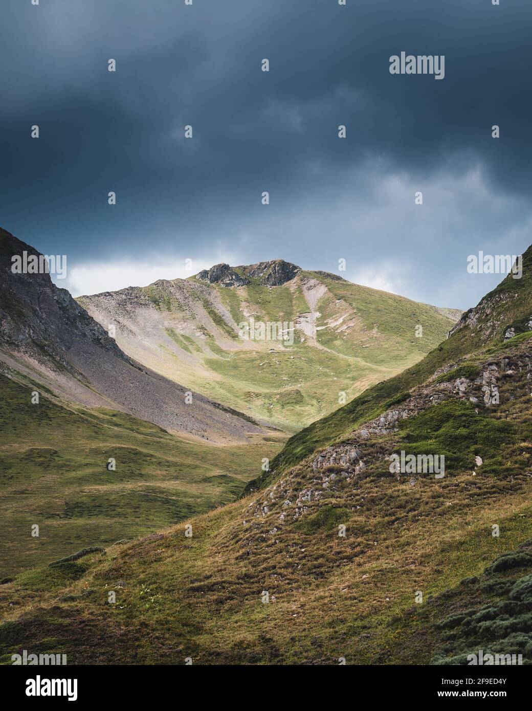 Landscape of Aran valley with majestic green hills and dark gray gloomy ...