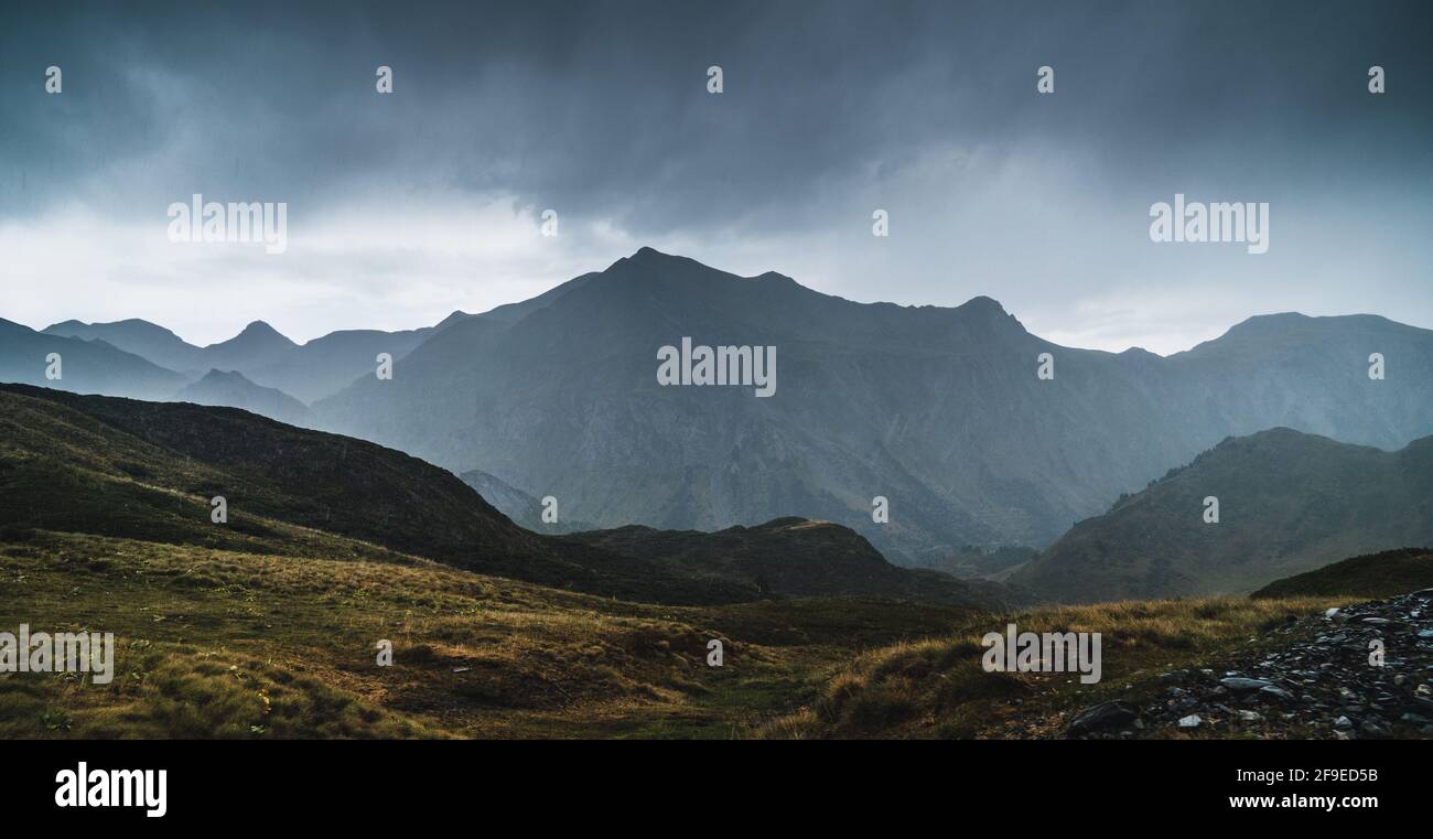Landscape of Aran valley with majestic green hills and dark gray gloomy ...