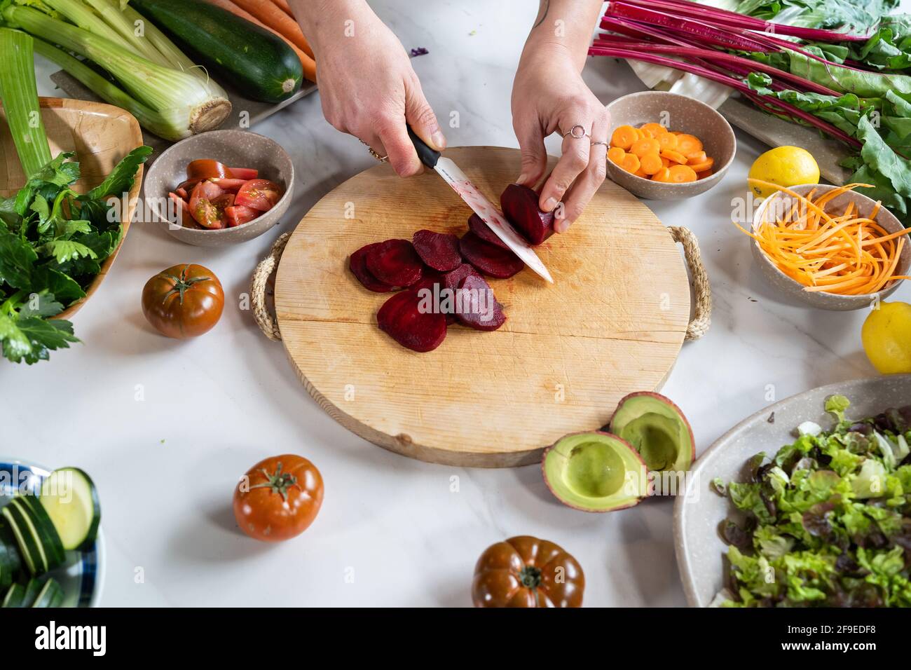 Crop unrecognizable female cutting fresh beetroot with knife while ...