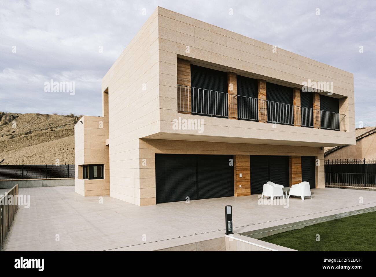 Contemporary masonry building exterior with fenced balcony against ...