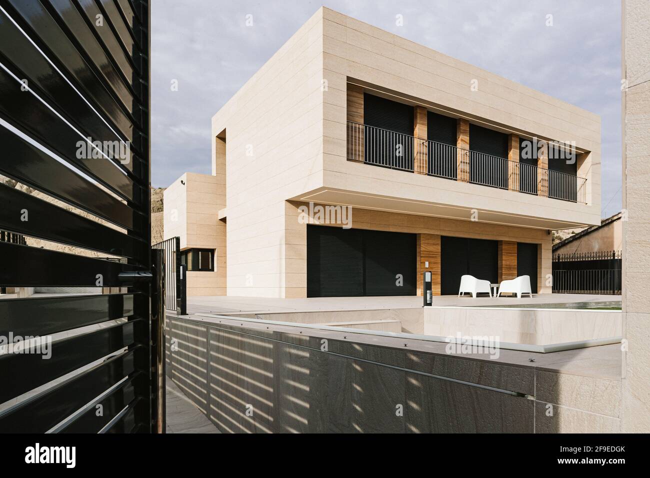 Contemporary masonry building exterior with fenced balcony against ...