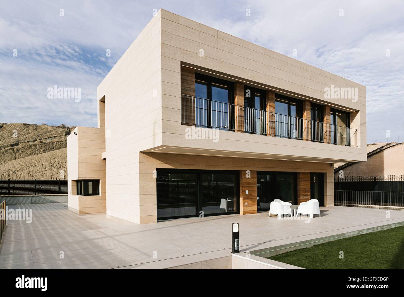 Contemporary masonry building exterior with fenced balcony against ...