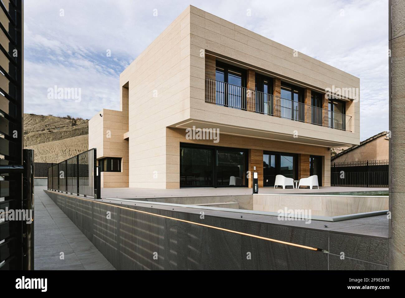 Contemporary masonry building exterior with fenced balcony against ...