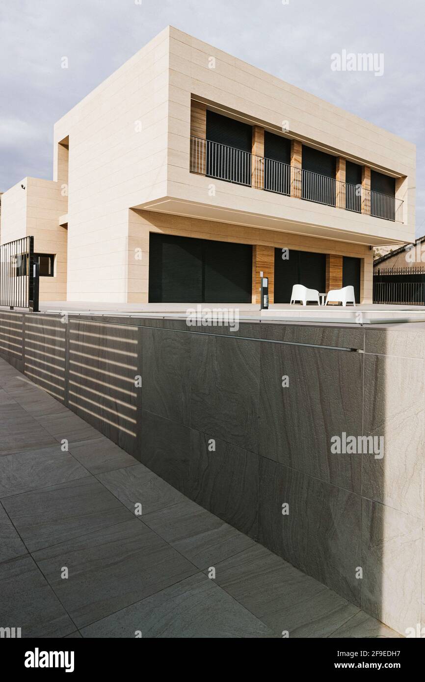 Contemporary masonry building exterior with fenced balcony against ...