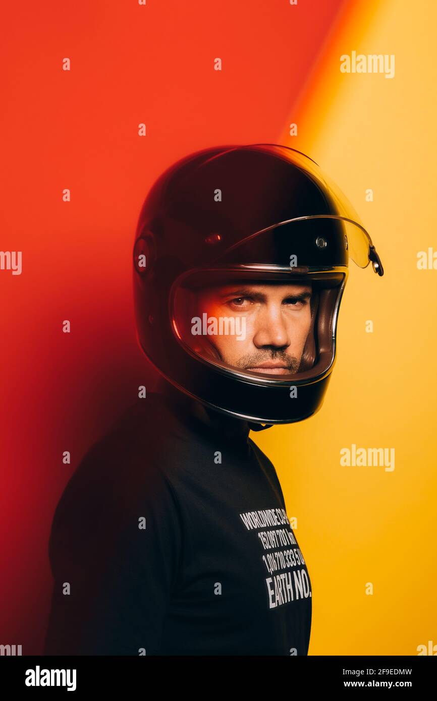 Side view of confident brutal adult man in black motorcycle helmet ...