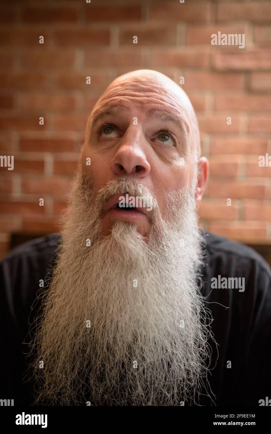 Portrait of mature man feeling surprised and scared while looking up ...