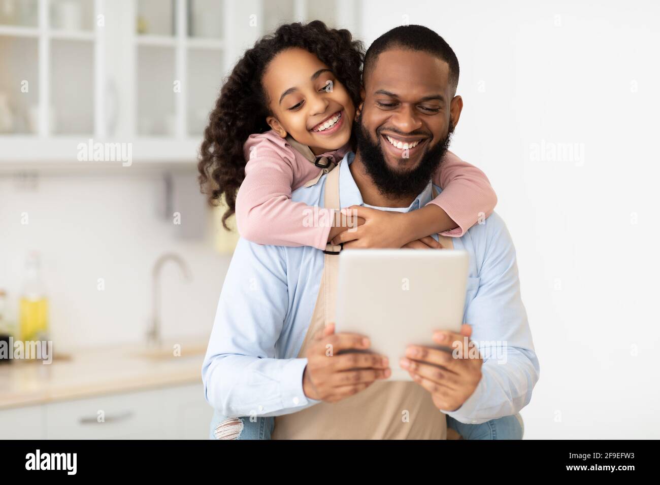 Happy African American family using tablet in the kitchen Stock Photo ...