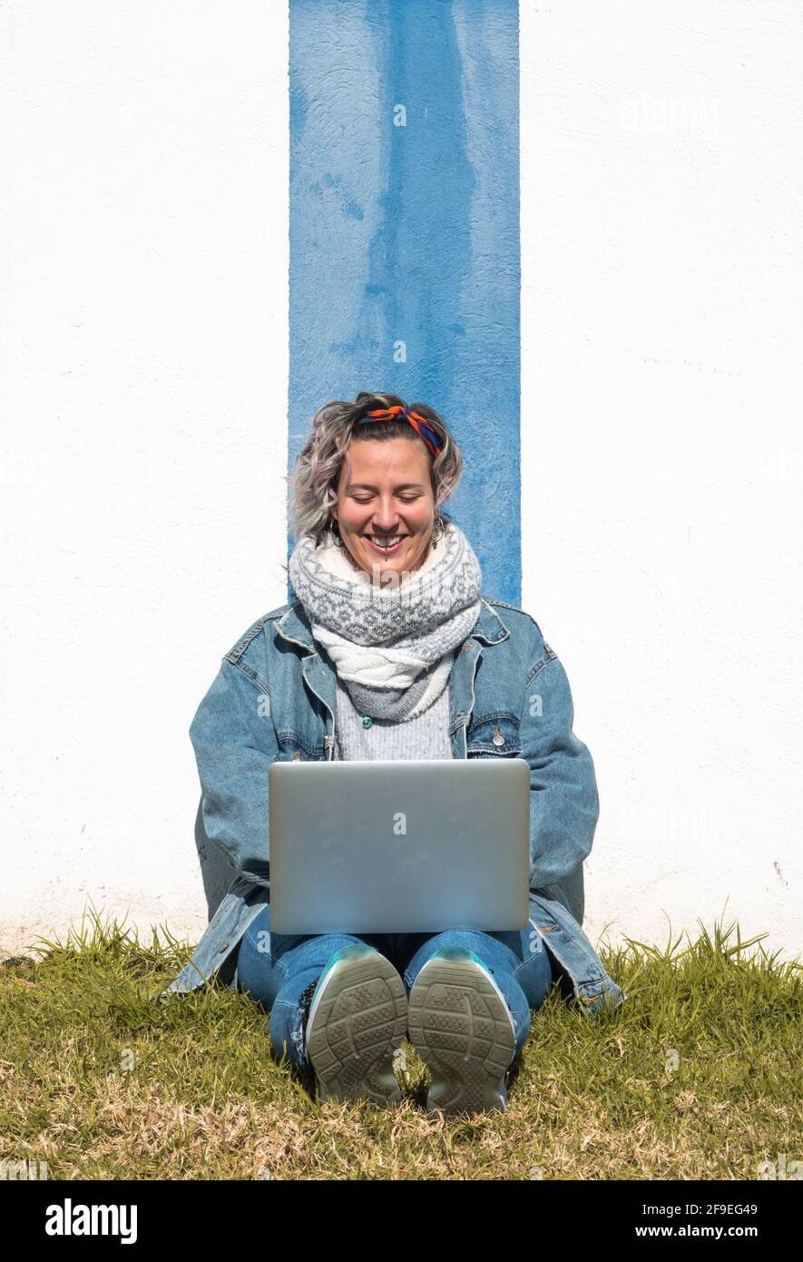 A Spanish woman having a conversation over her laptop while leaning ...