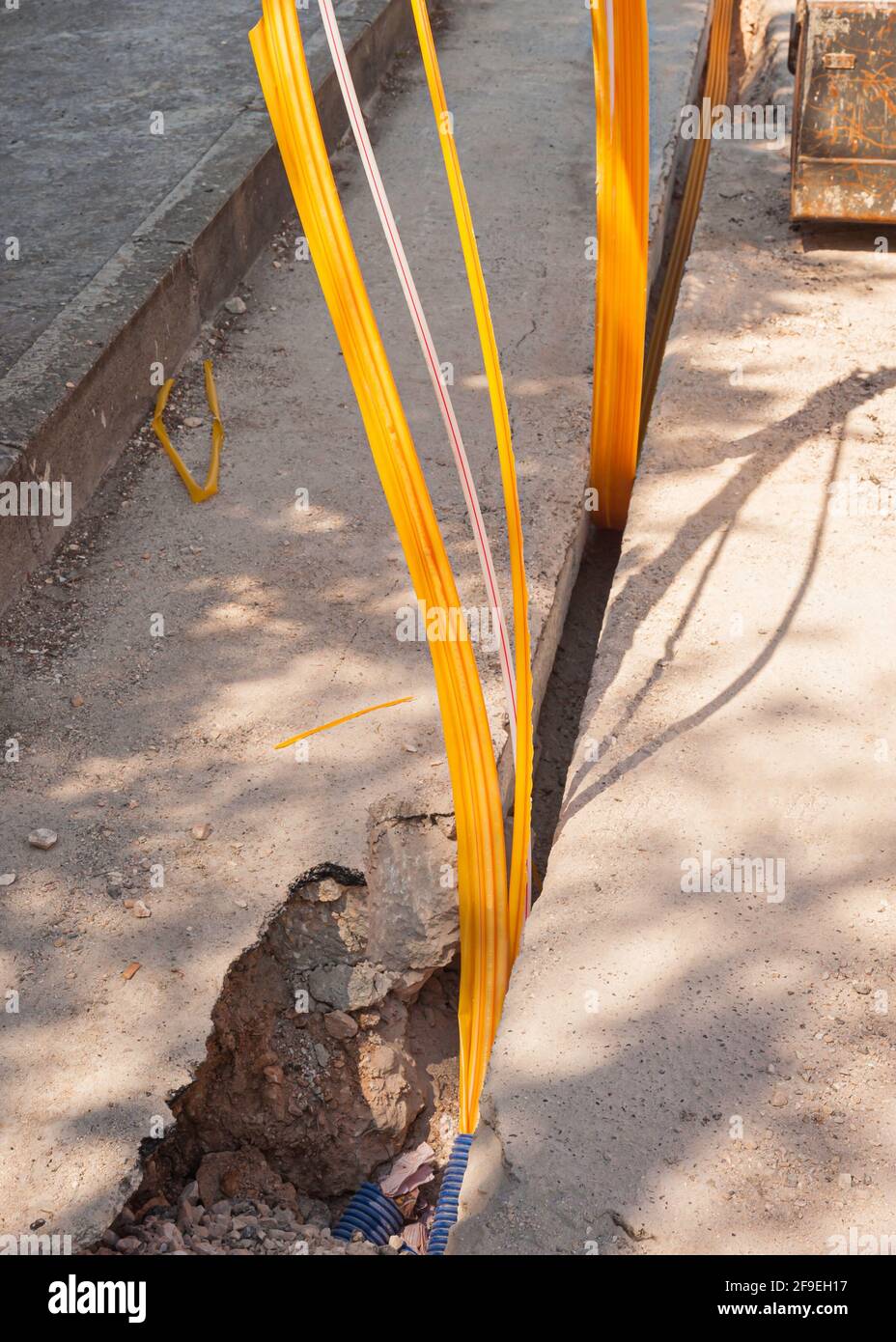Worker inserts fiber optic cables buried in a micro trench Stock Photo ...