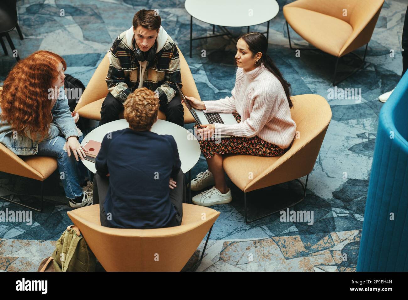 Teenagers at table working on project in college. Students in campus ...