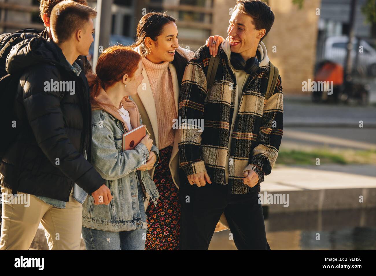 Happy students walking outdoors after class in college campus. Cheerful ...