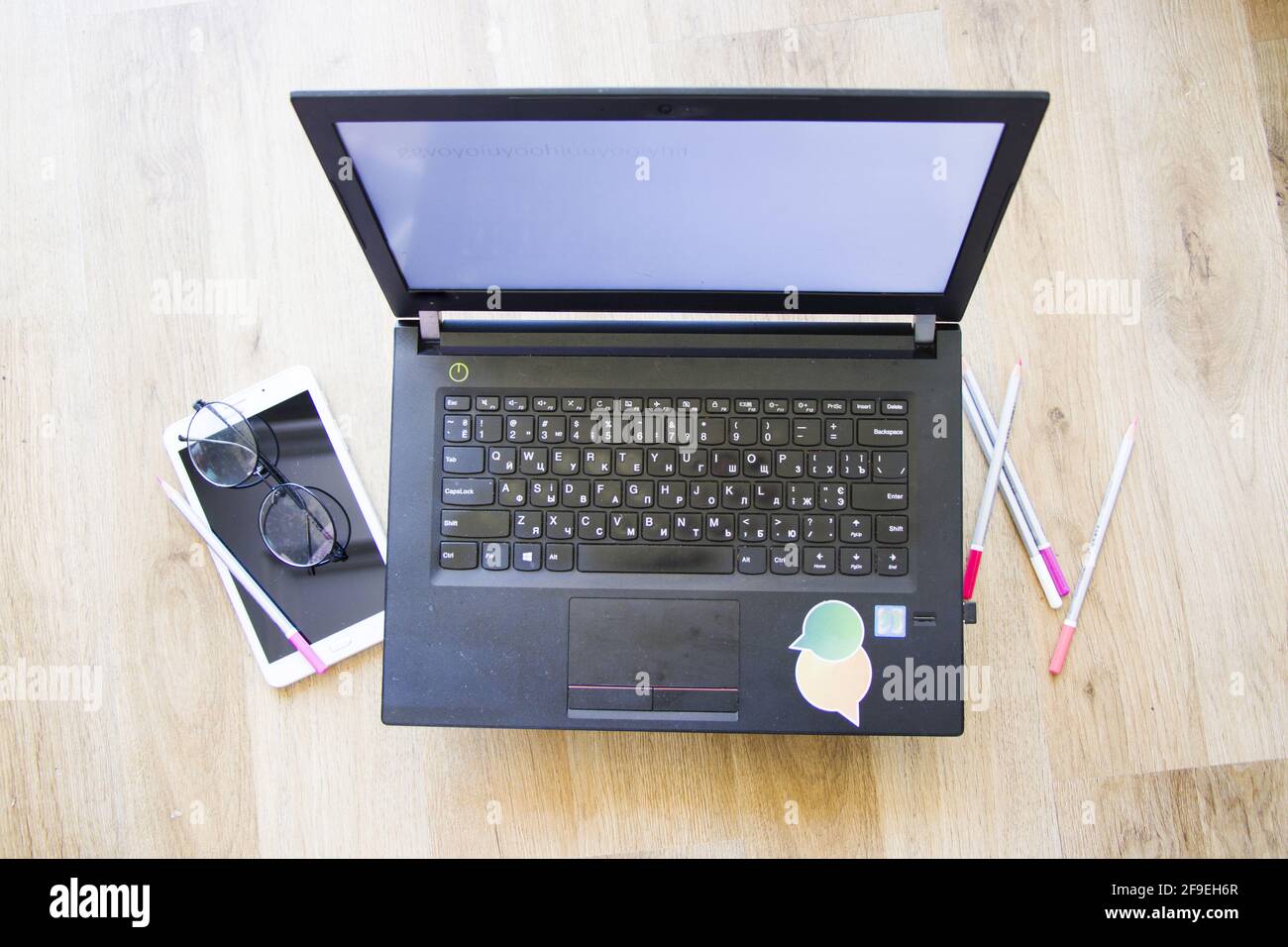 A top view of a laptop placed on the floor with other work-related ...